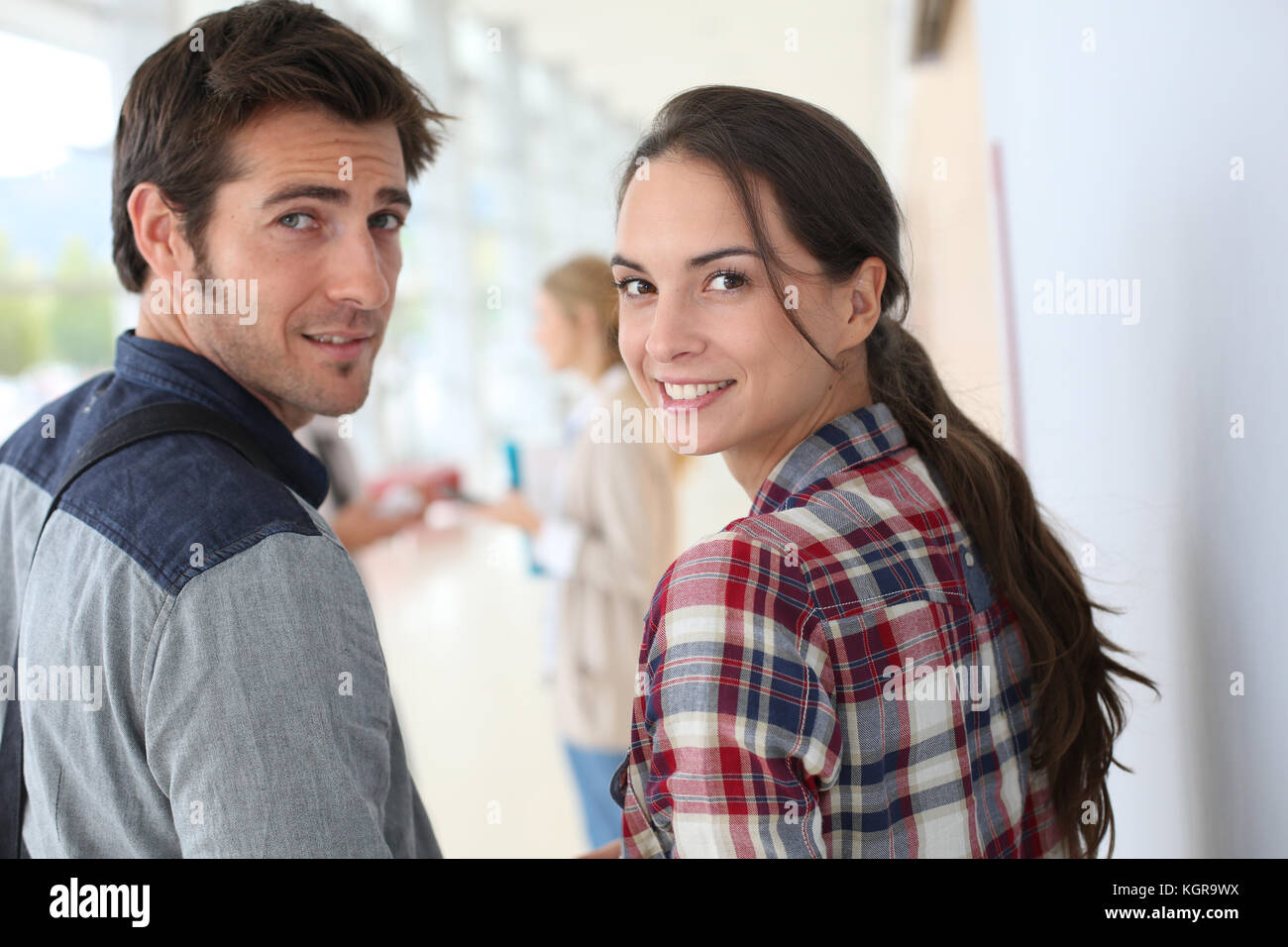 Friends standing in university hallway Stock Photo - Alamy