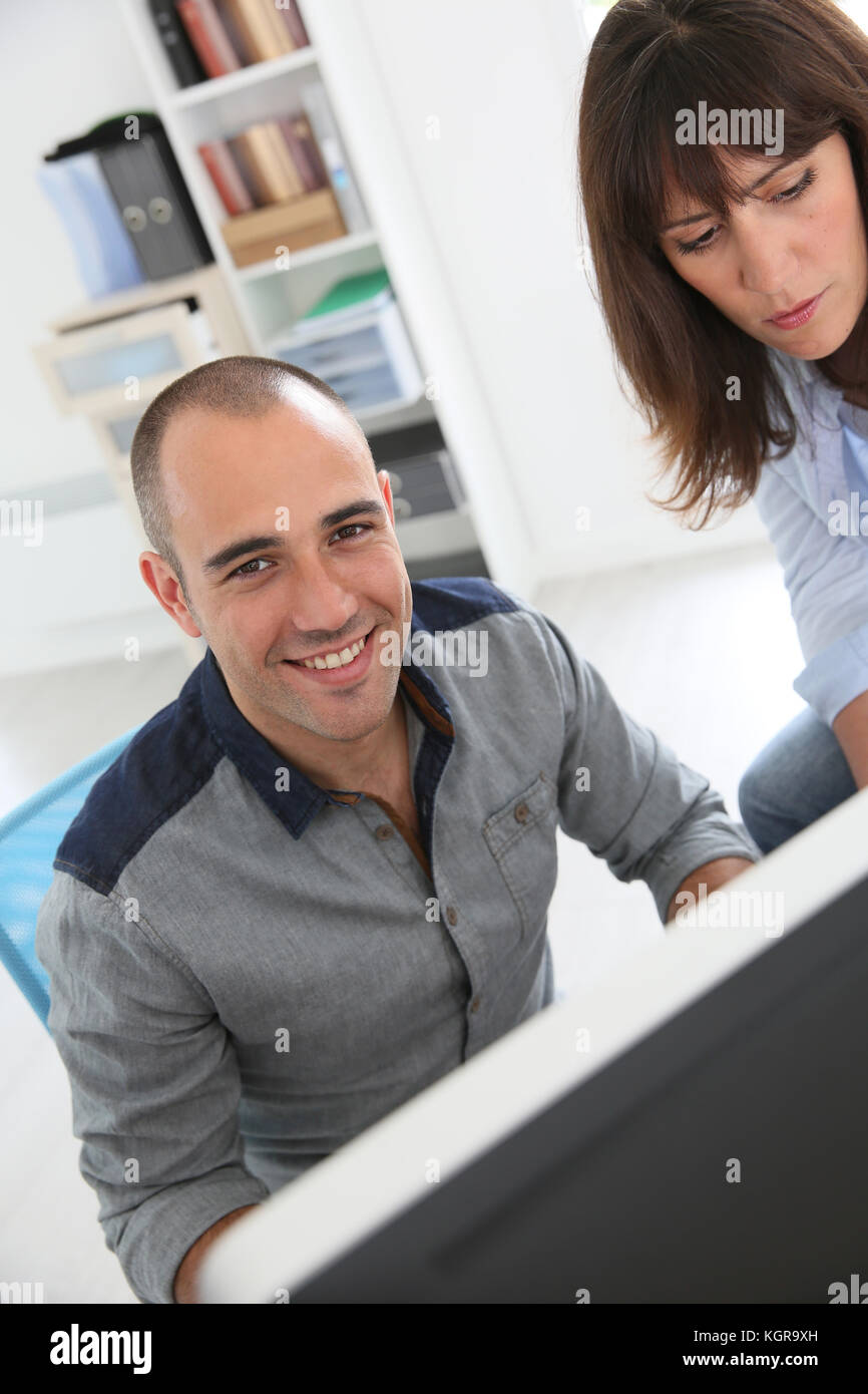 Workmates working on desktop computer Stock Photo - Alamy