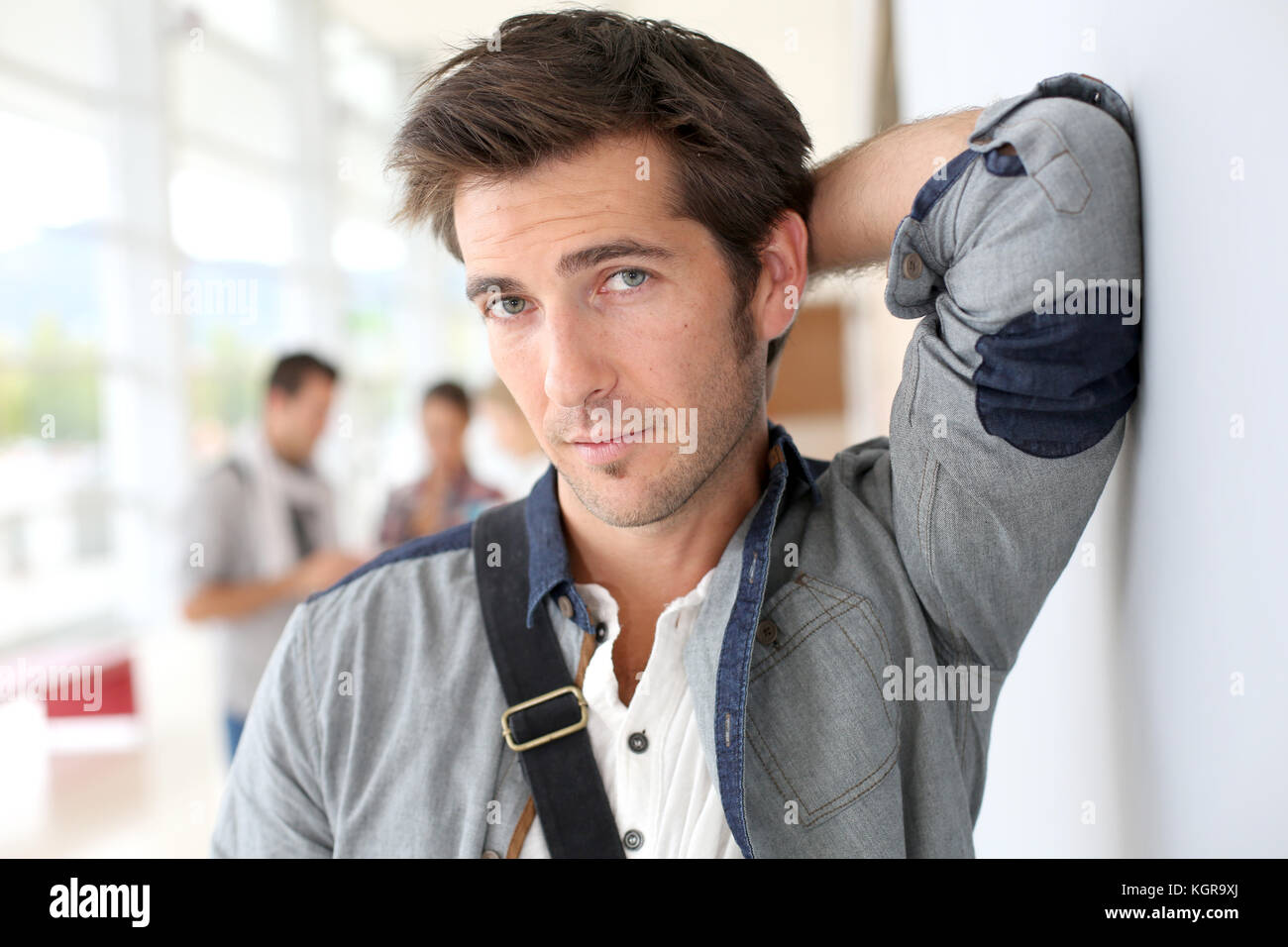 Handsome relaxed young man in school hallway Stock Photo - Alamy
