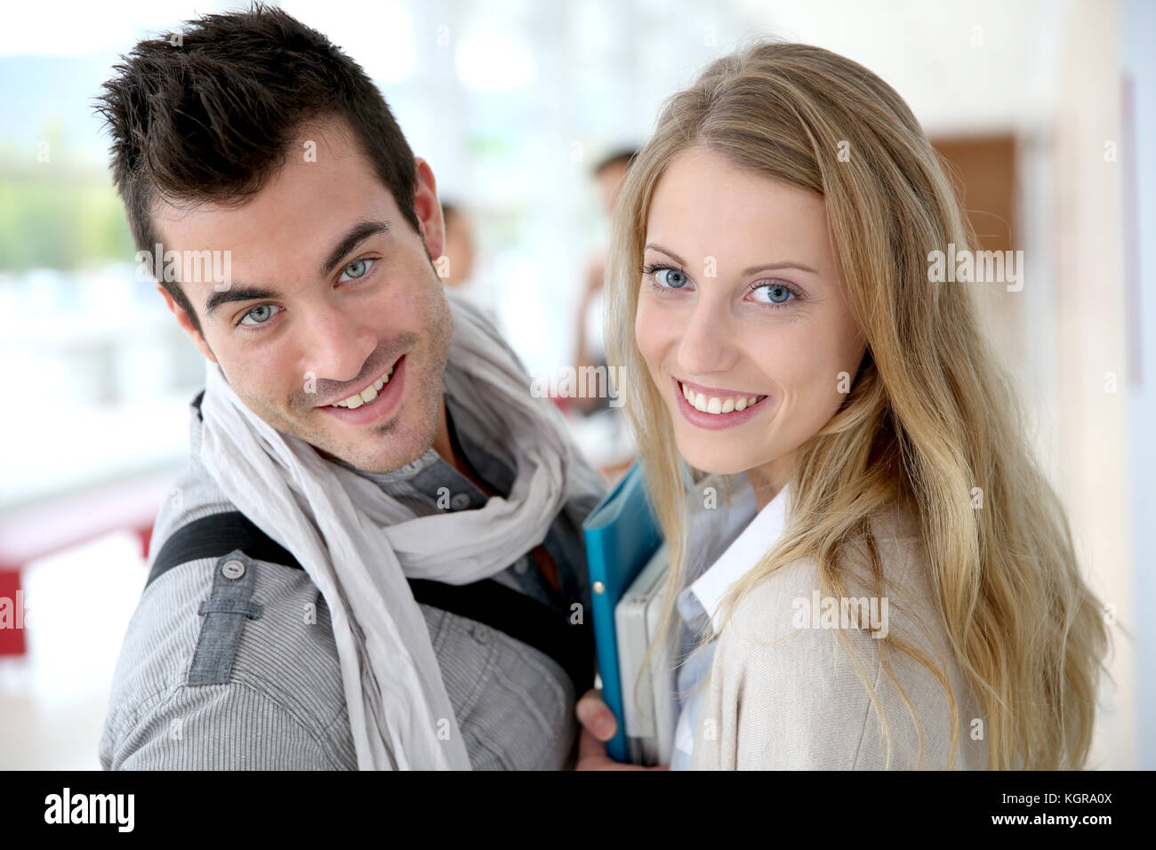 Friends standing in university hallway Stock Photo - Alamy