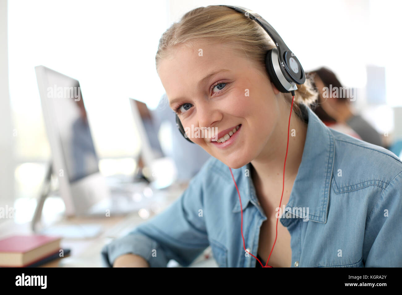Blond student girl in computing class with headphones on Stock Photo ...