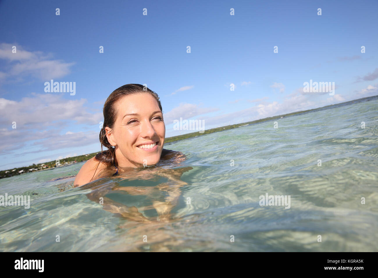 Portrait of smiling woman enjoying swimming in lagoon Stock Photo - Alamy