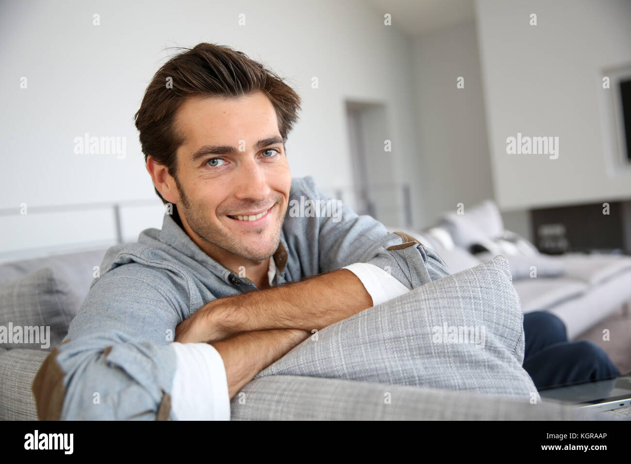 Single man relaxing in sofa at home Stock Photo - Alamy