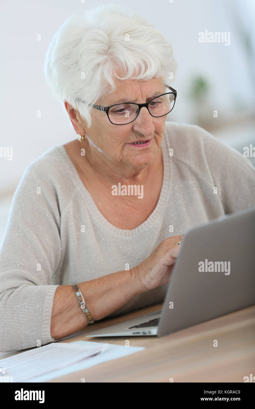 Elderly woman using laptop computer at home Stock Photo - Alamy