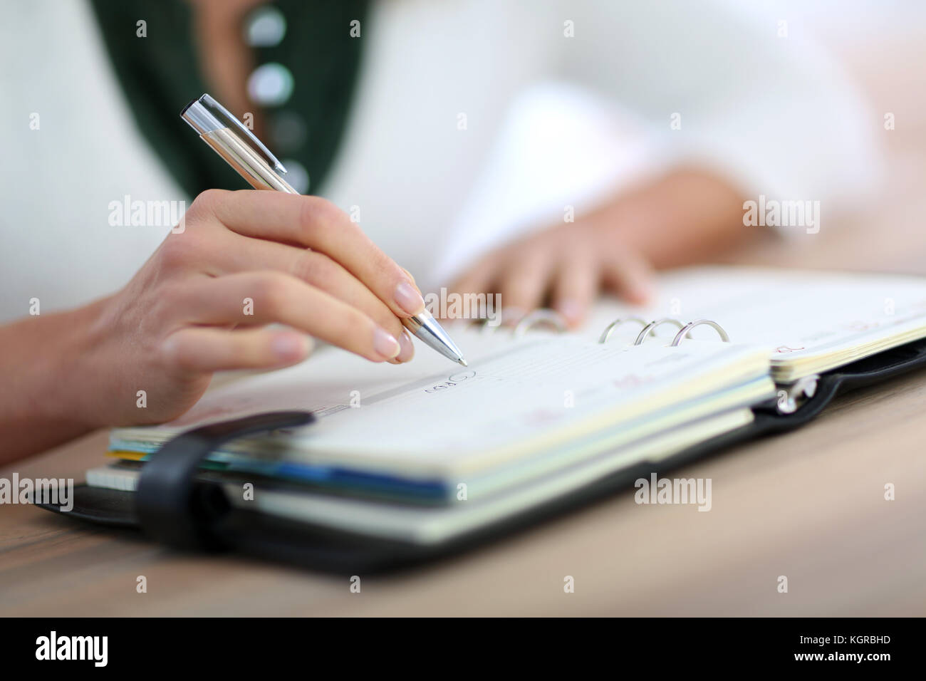 Closeup of woman's hand writing on agenda Stock Photo - Alamy