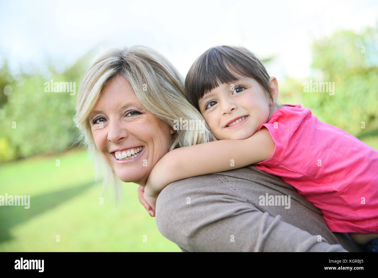 Mother giving piggyback ride to little girl Stock Photo - Alamy