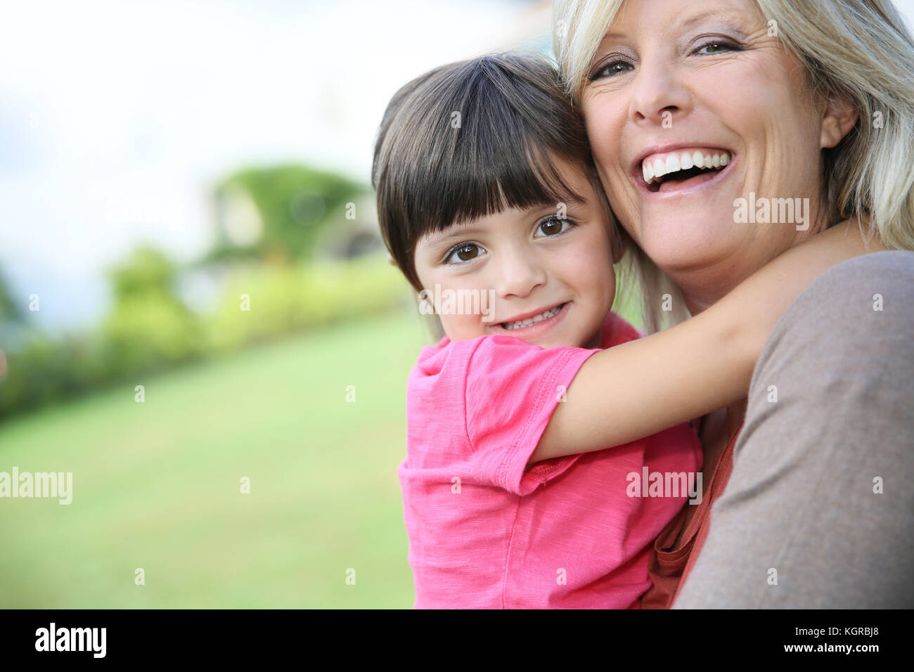 Cheerful woman embracing little girl in arms Stock Photo - Alamy