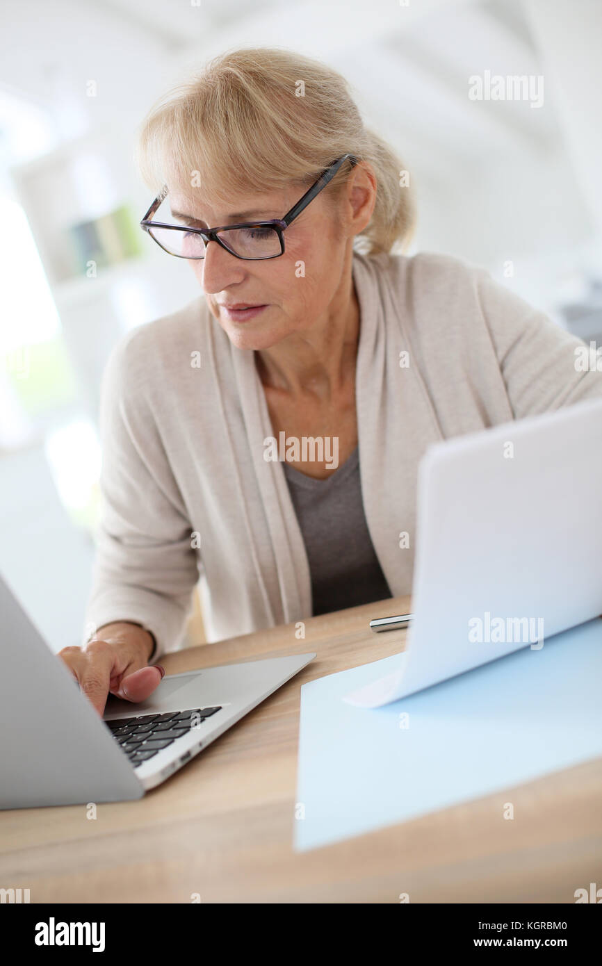 Senior woman filling form online with laptop Stock Photo - Alamy