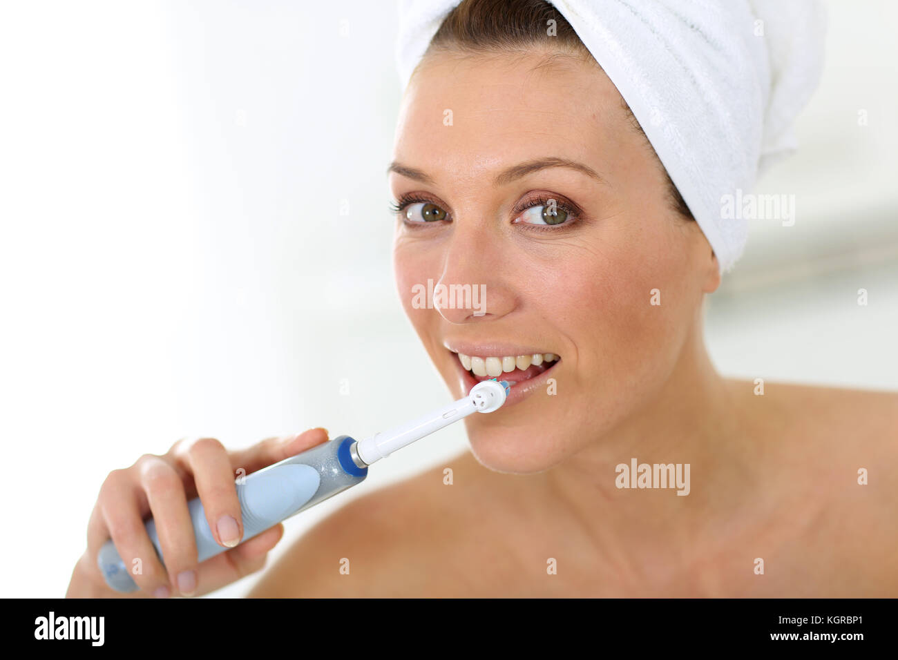 Woman brushing her teeth with electrical toothbrush Stock Photo - Alamy