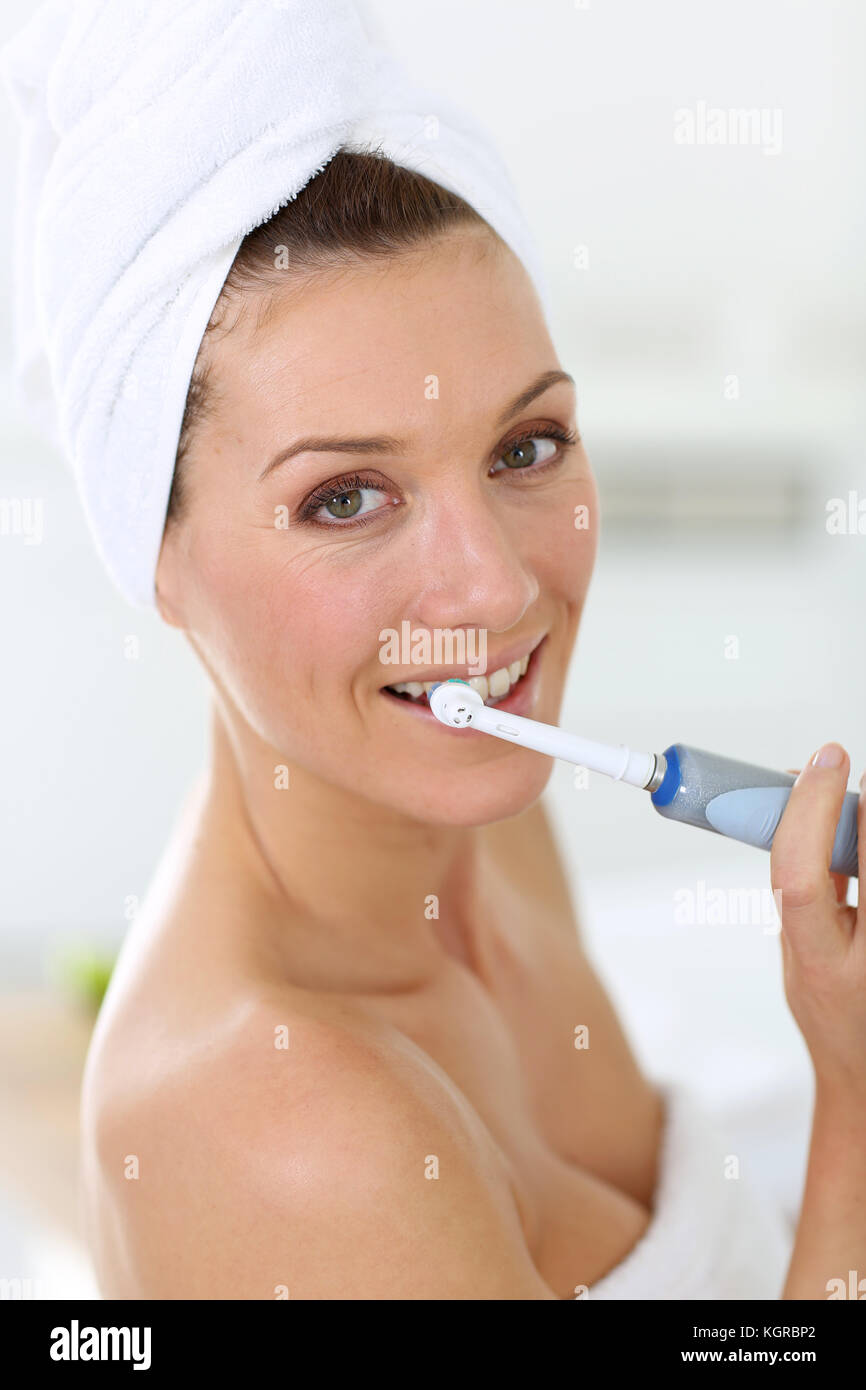 Woman brushing her teeth with electrical toothbrush Stock Photo - Alamy