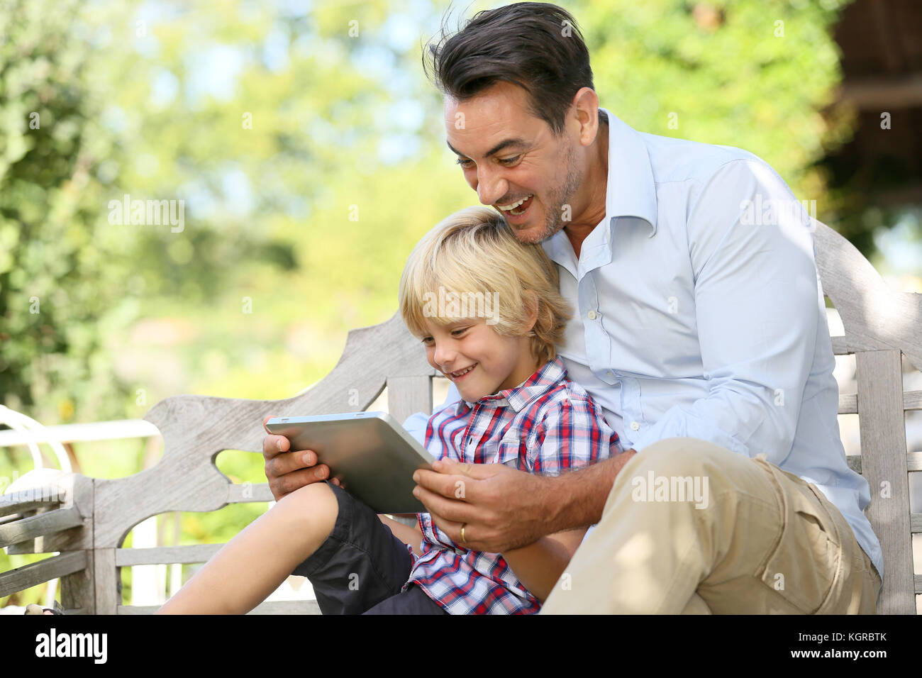 Daddy and son playing with tablet outside Stock Photo - Alamy