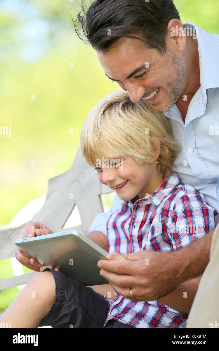 Daddy and son playing with tablet outside Stock Photo - Alamy