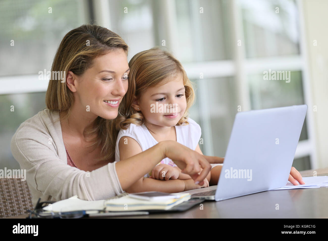 Little girl looking at laptop computer with her mom Stock Photo - Alamy