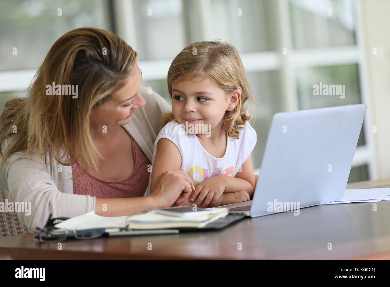 Little girl looking at laptop computer with her mom Stock Photo - Alamy