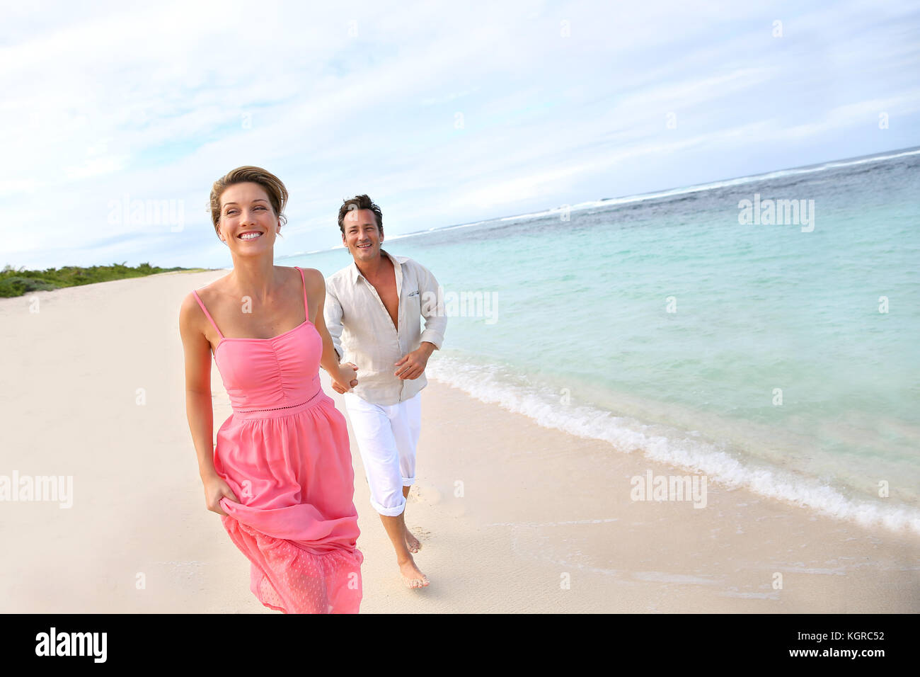 Romantic couple running on a sandy beach Stock Photo - Alamy