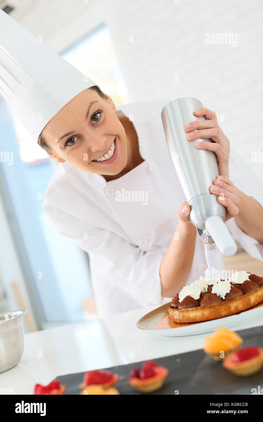 Pastry cook spreading whipped cream on tart Stock Photo - Alamy