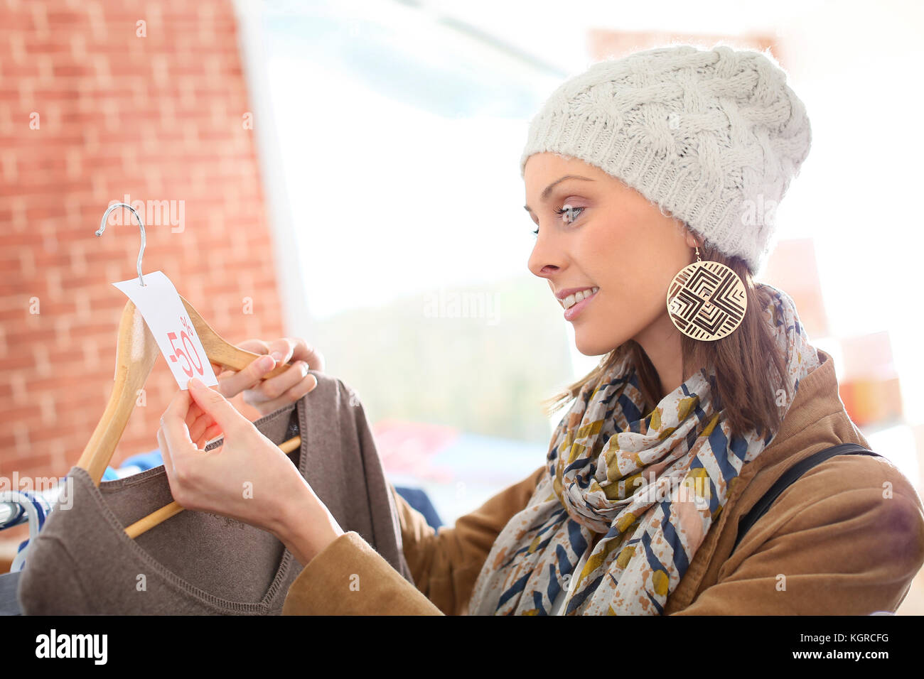 Beautiful woman in store choosing clothes on sale Stock Photo - Alamy