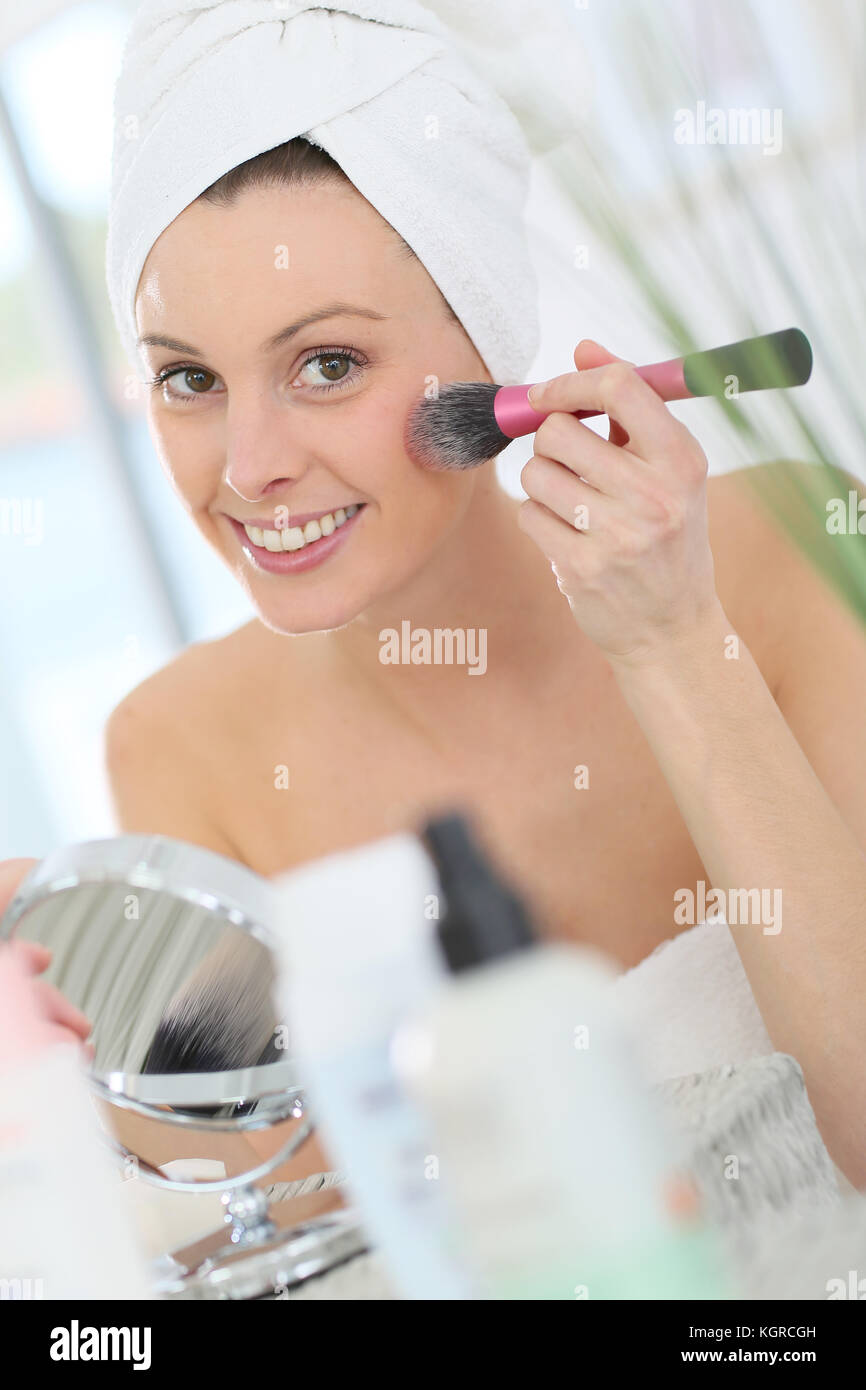 Beautiful woman putting makeup on Stock Photo - Alamy
