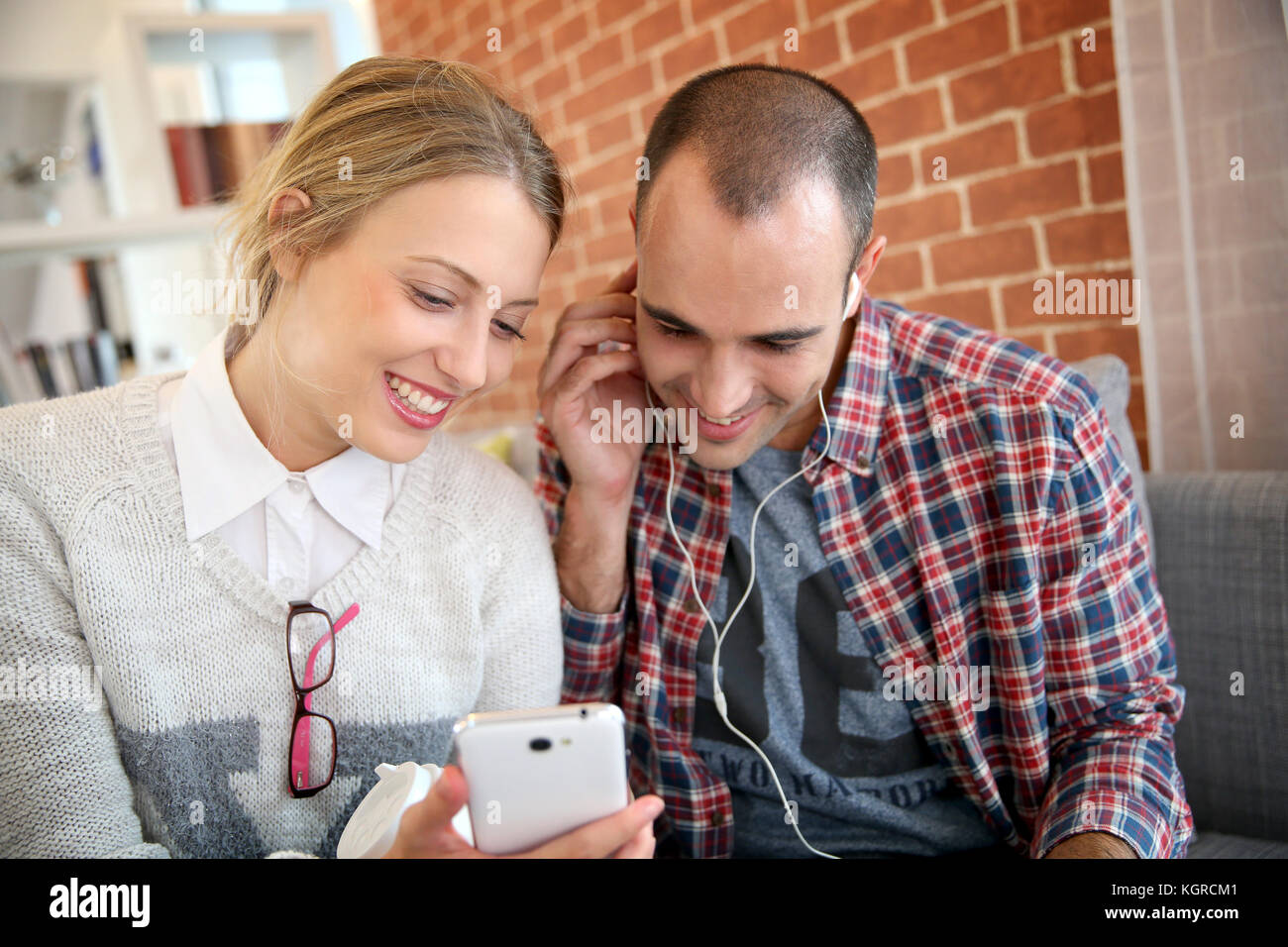 Friends having fun listening to music on smartphone Stock Photo - Alamy