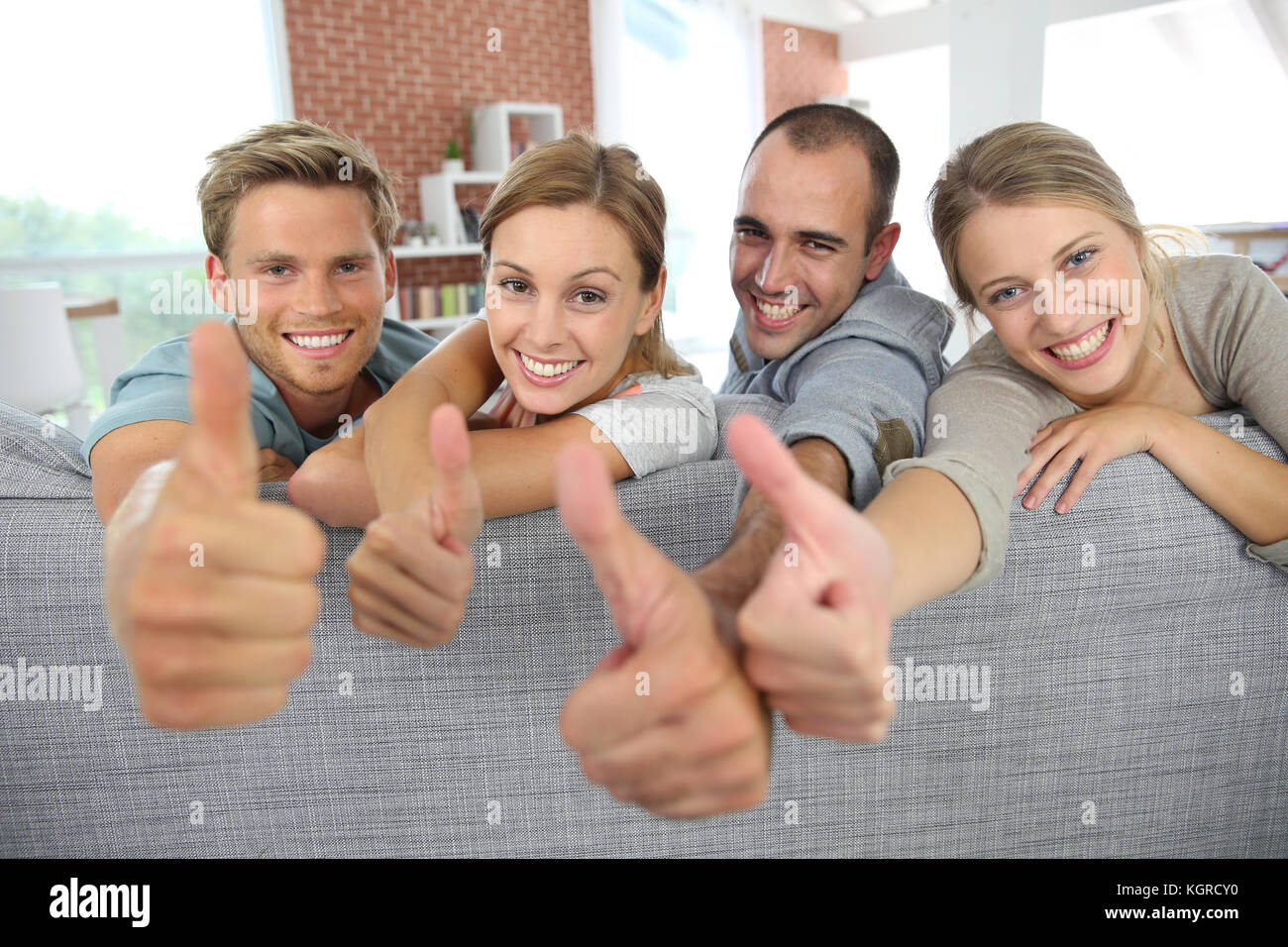 Cheerful roommates showing thumbs up Stock Photo - Alamy