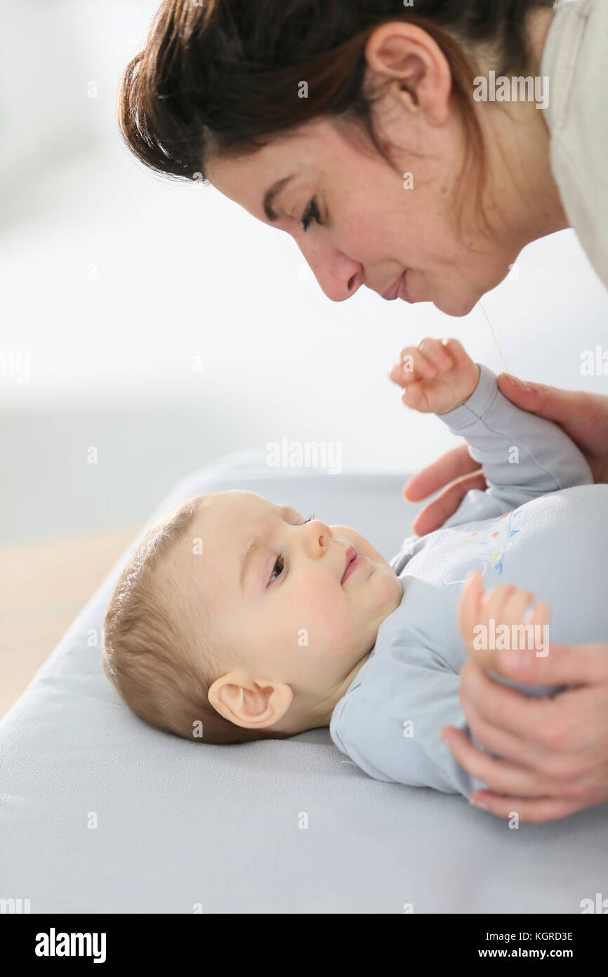 Mommy cuddling baby boy on changing table Stock Photo - Alamy