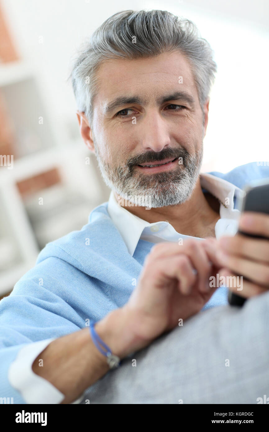 Mature man sending message with smartphone Stock Photo - Alamy