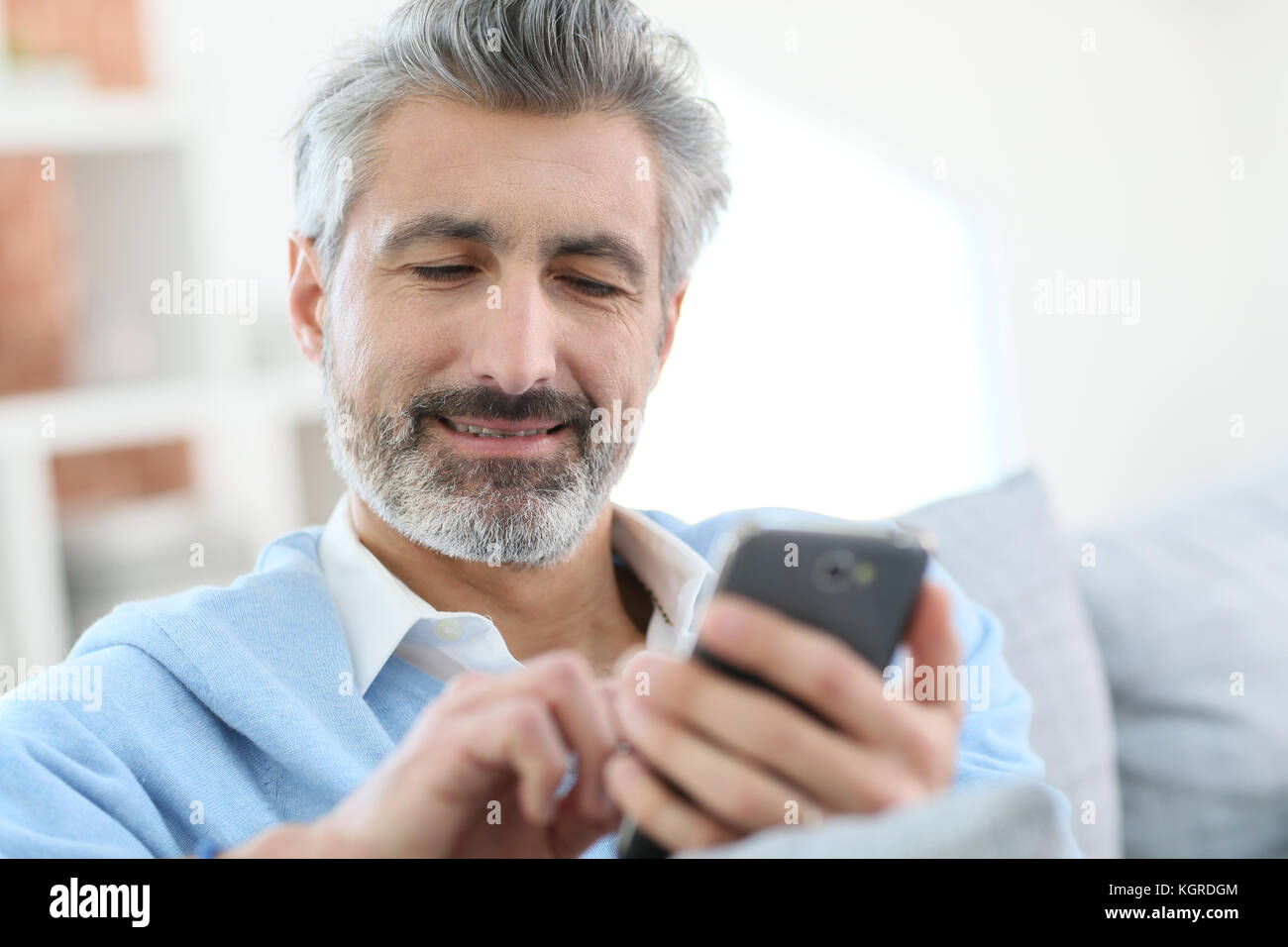 Mature man sending message with smartphone Stock Photo - Alamy