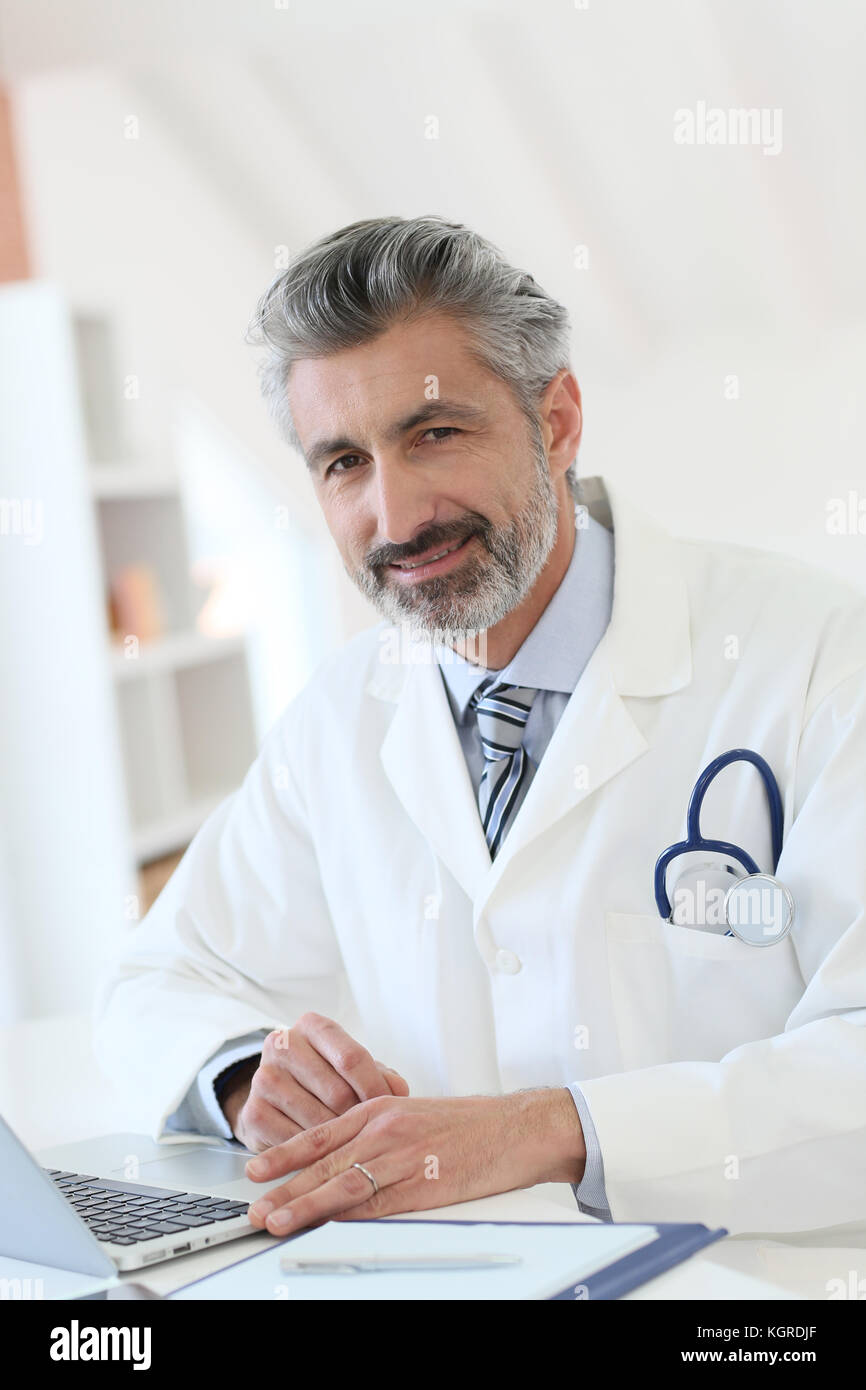 Doctor working in office on laptop Stock Photo - Alamy