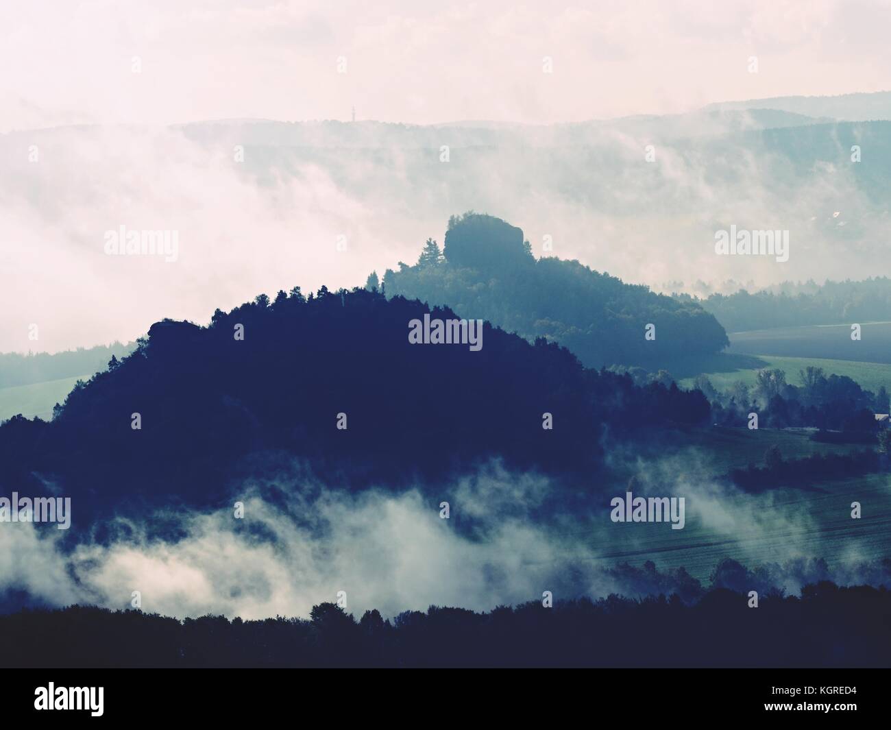 Autumn sunrise in a beautiful mountain within inversion. Peaks of hills ...