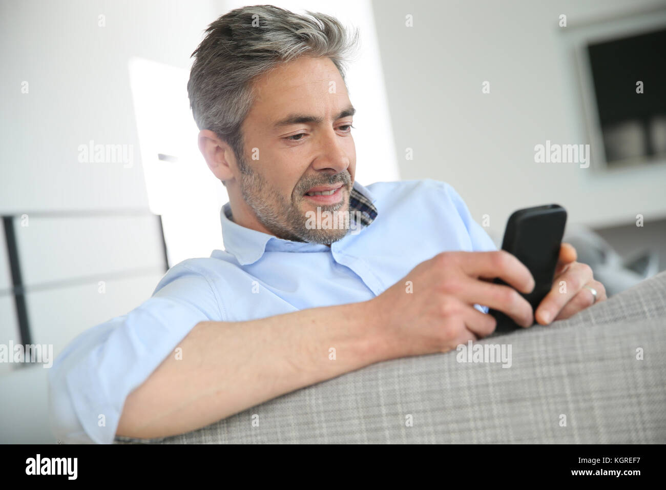 Mature man sending message with smartphone Stock Photo - Alamy
