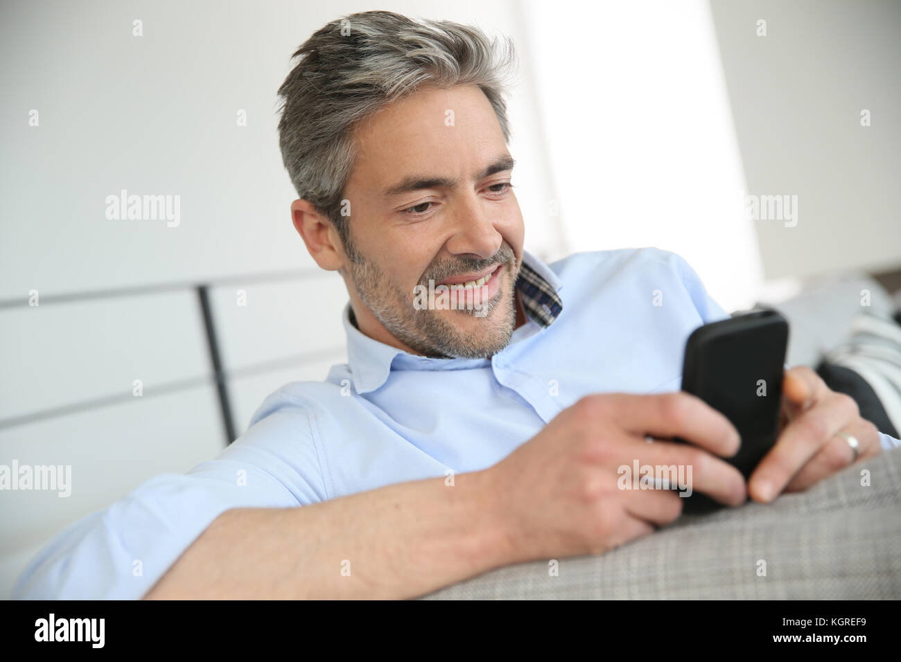 Mature man sending message with smartphone Stock Photo - Alamy
