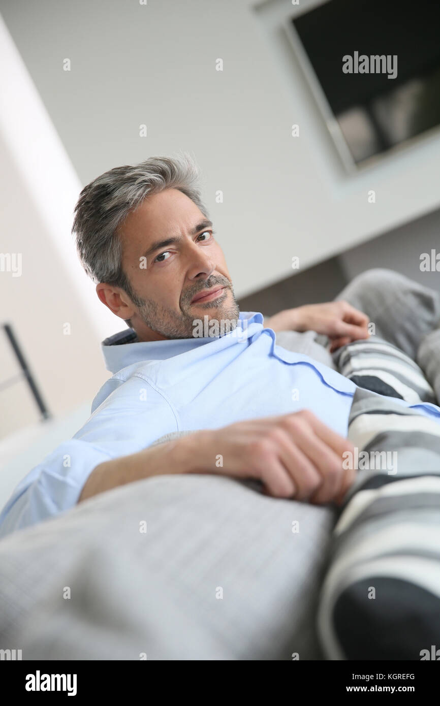 Mature man in living-room, relaxing in sofa Stock Photo - Alamy