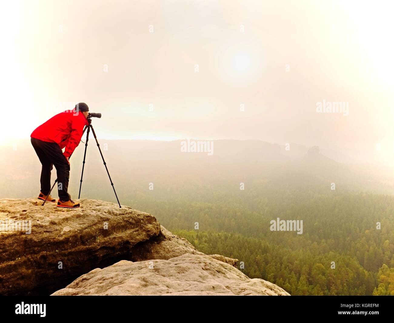 Photographr looking into viewfinder of dslr digital camera stand on ...