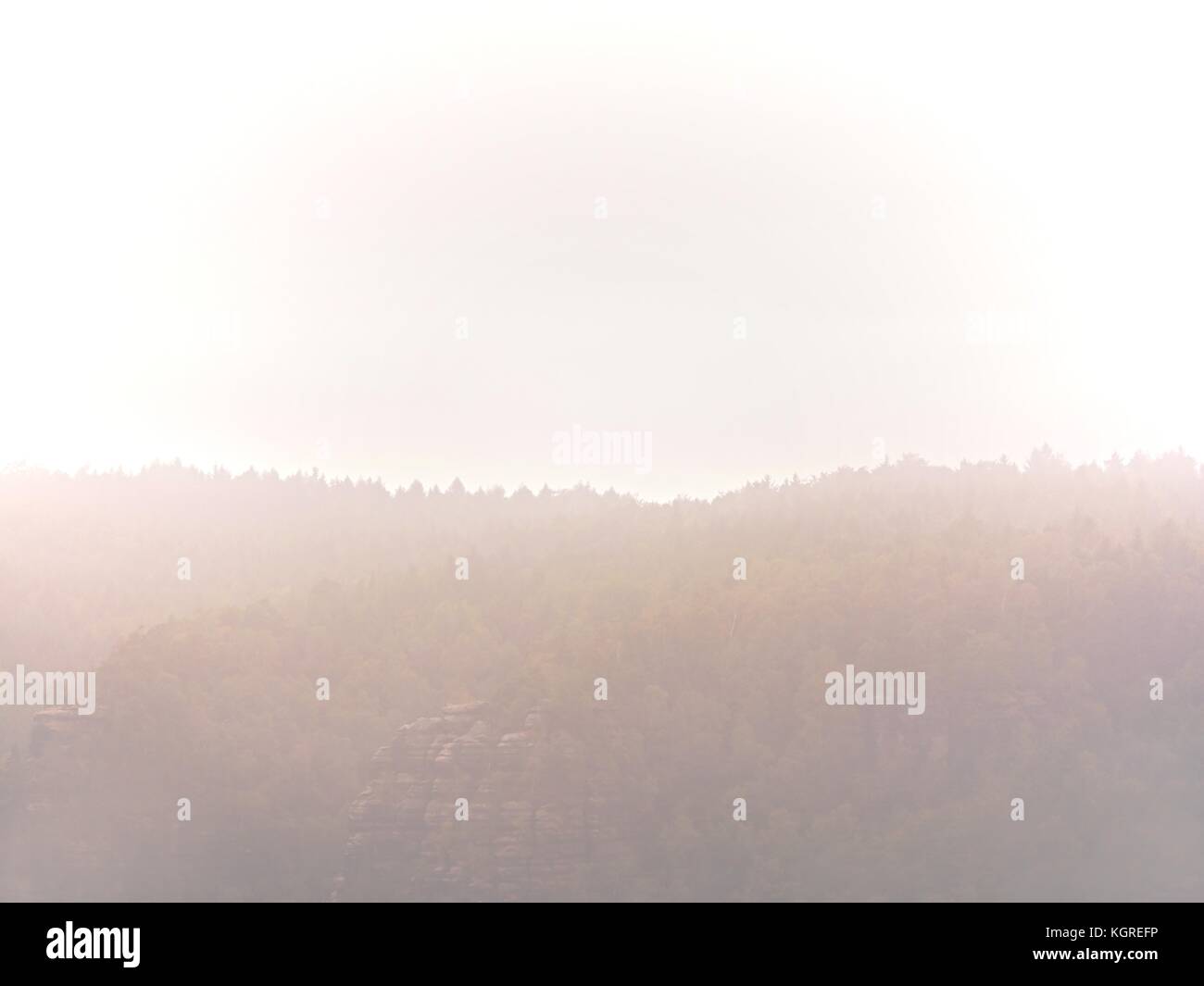 Cold and damp morning in autumn nature. Outlines of forest hills hidden ...