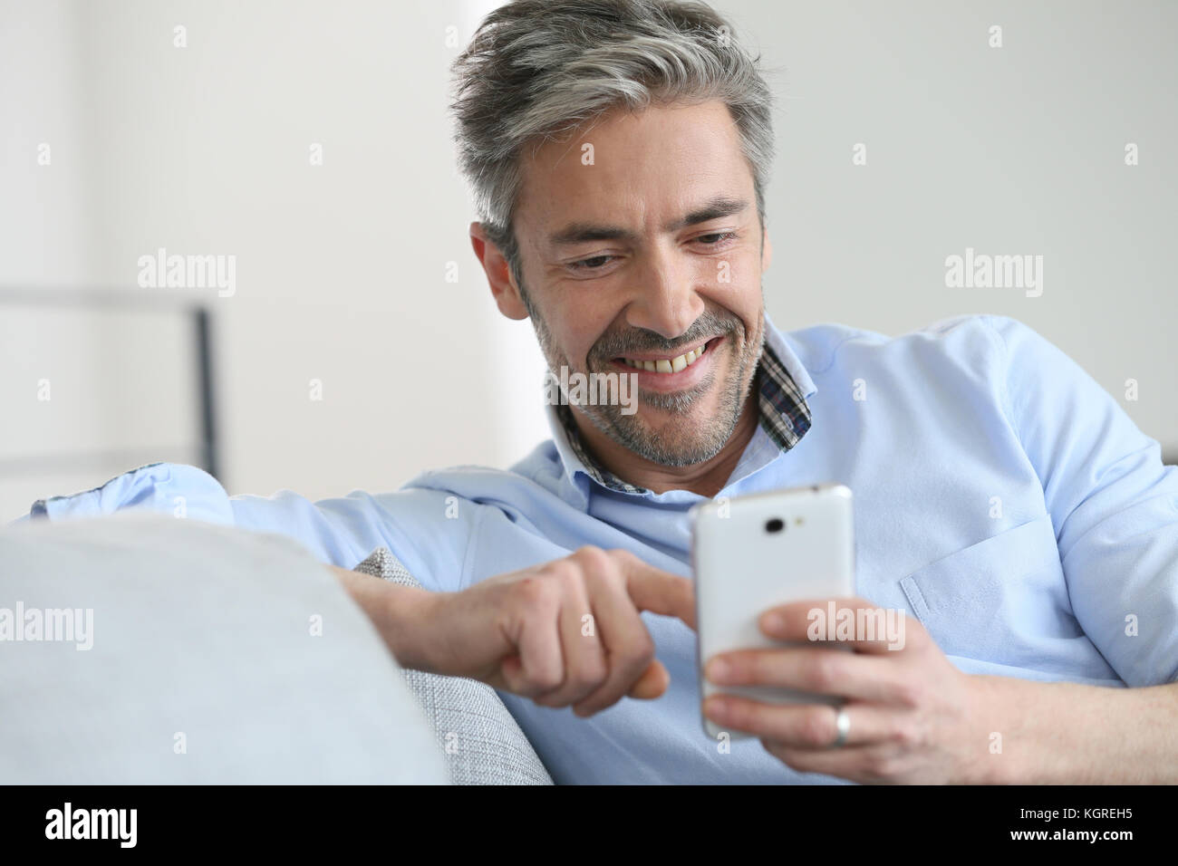 Mature man sending message with smartphone Stock Photo - Alamy
