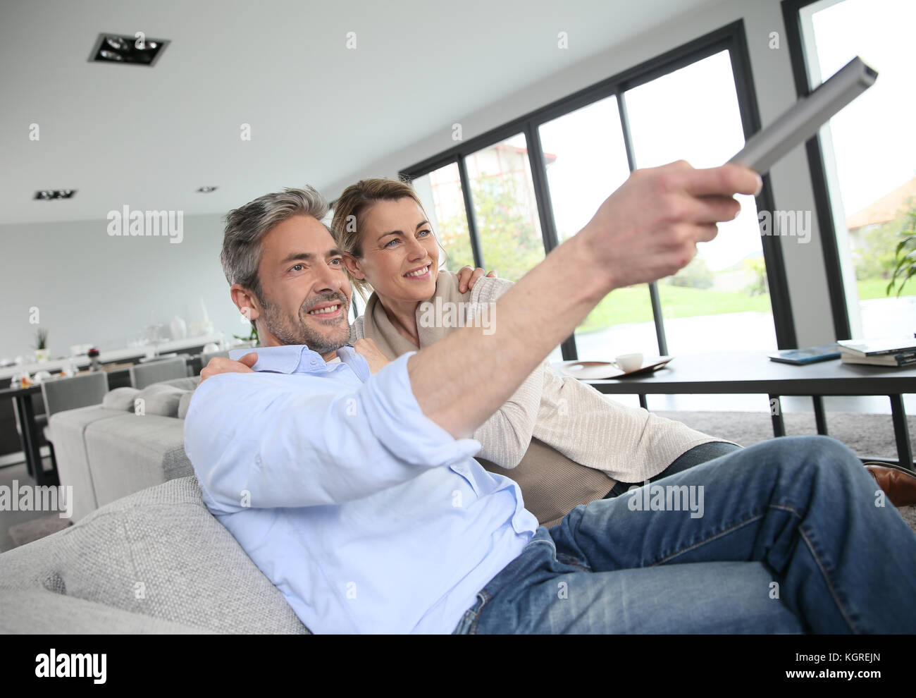 Middle-aged couple in living-room watching television Stock Photo - Alamy