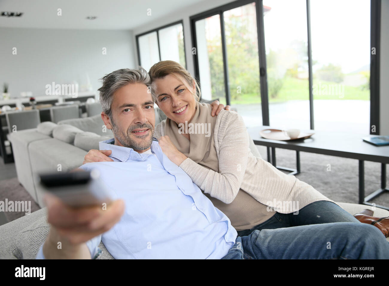 Middle-aged couple in living-room watching television Stock Photo - Alamy