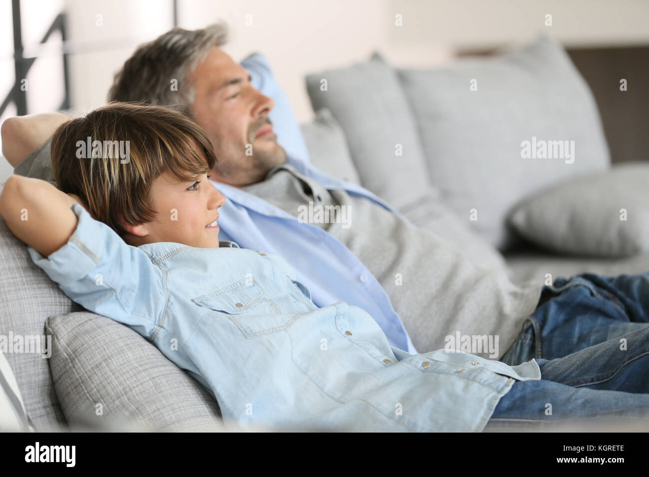 Father and son relaxing in sofa a thome Stock Photo - Alamy