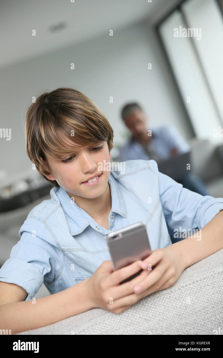 Teenage boy using smartphone at home Stock Photo - Alamy