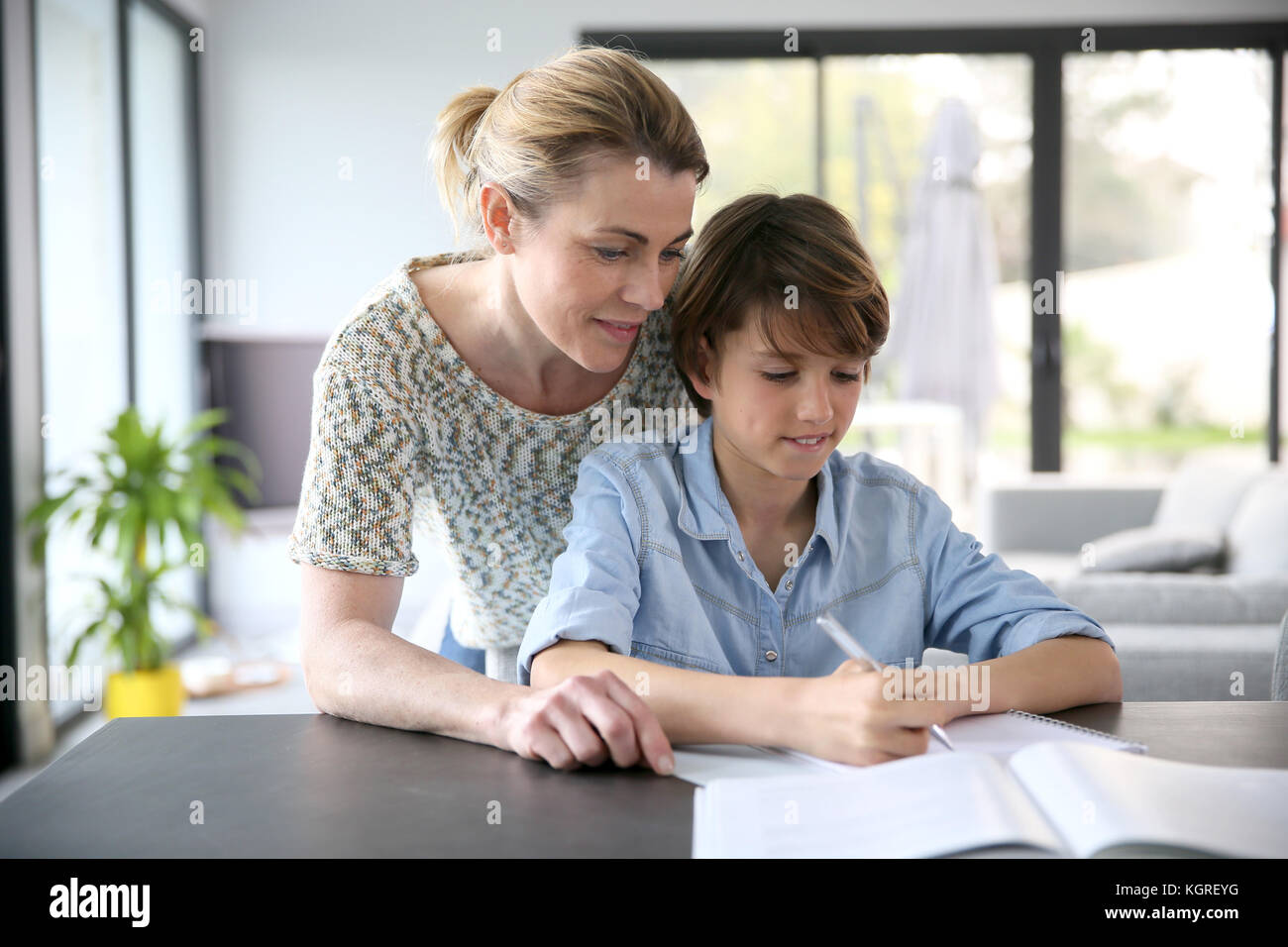 Mother helping kid with homework Stock Photo - Alamy