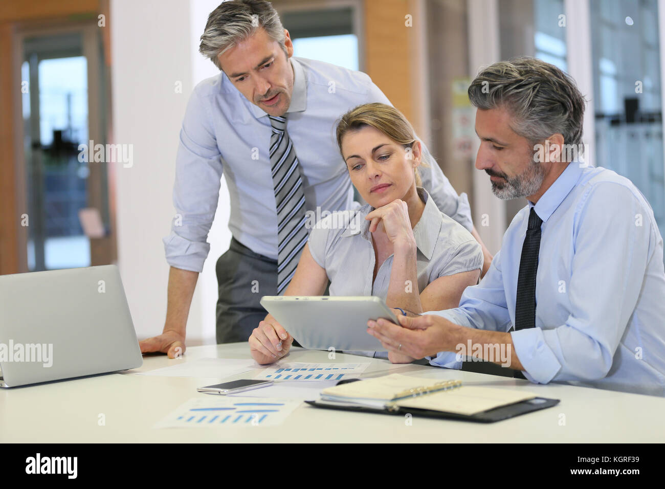 Sales people meeting in office, using tablet Stock Photo - Alamy