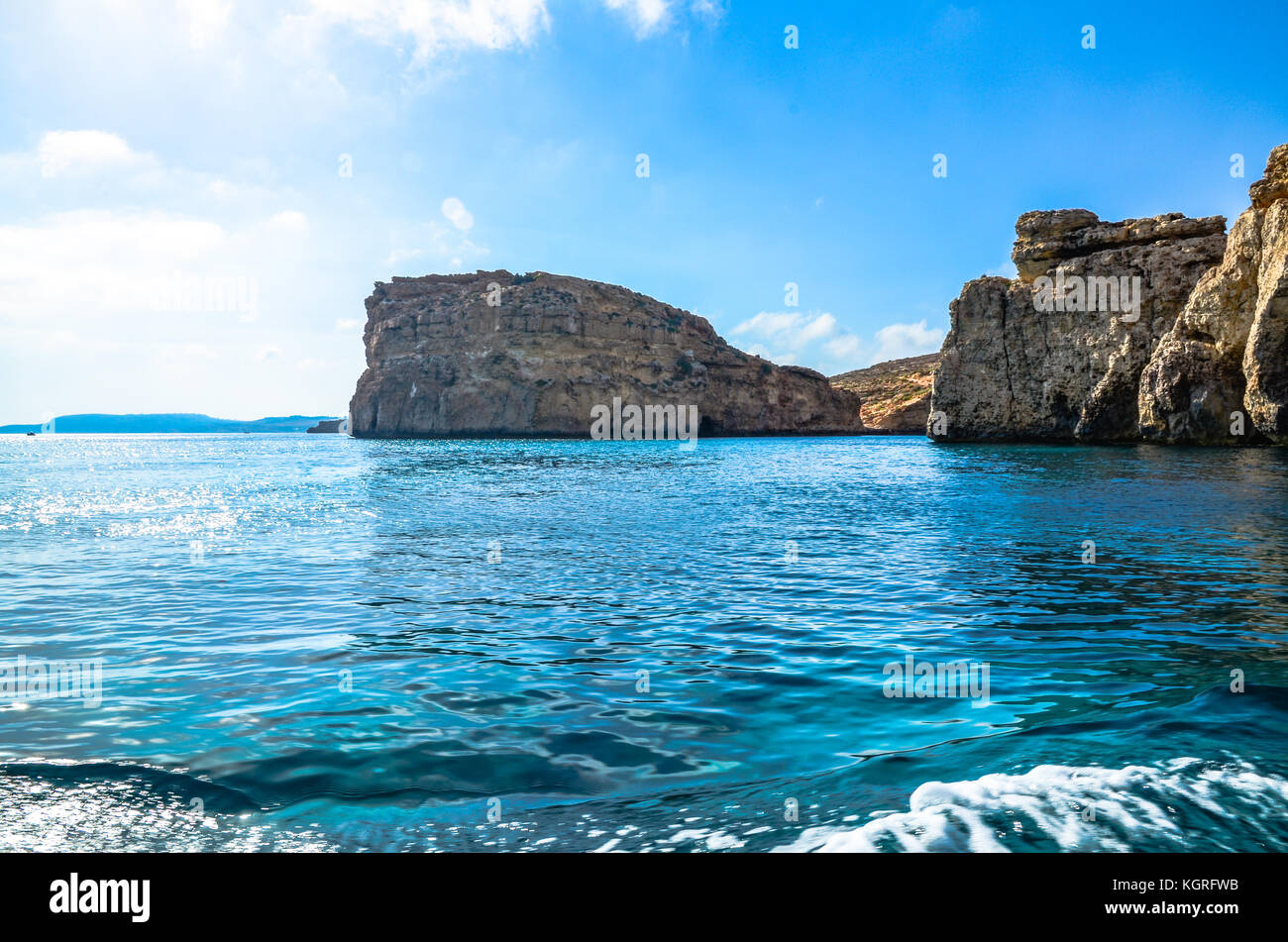 The turquoise Mediterranean waters with distant cliffs between Comino ...