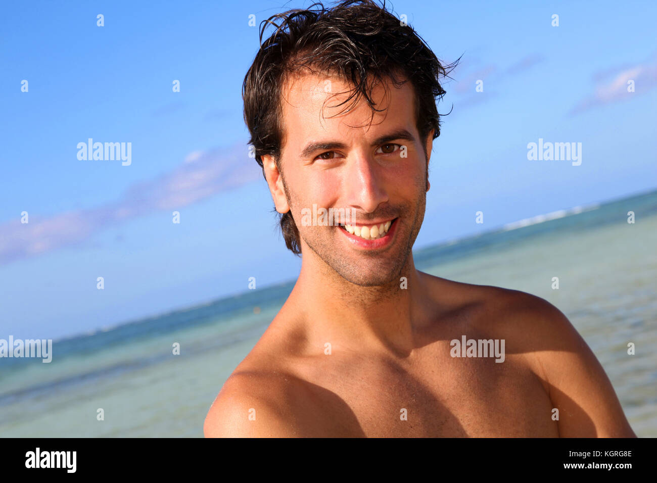 Handsome man standing on the beach Stock Photo - Alamy
