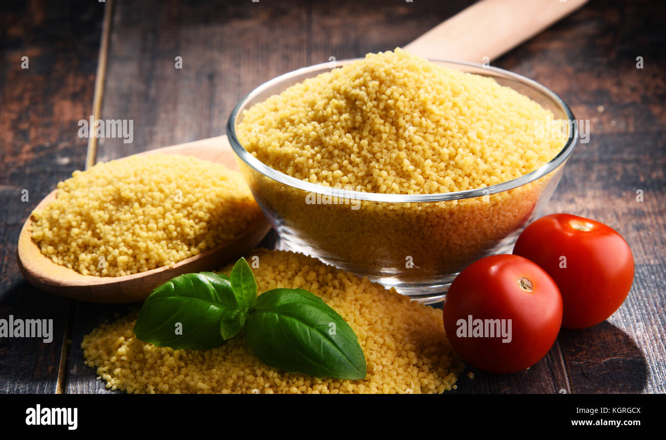 Bowl of uncooked couscous on wooden table Stock Photo - Alamy