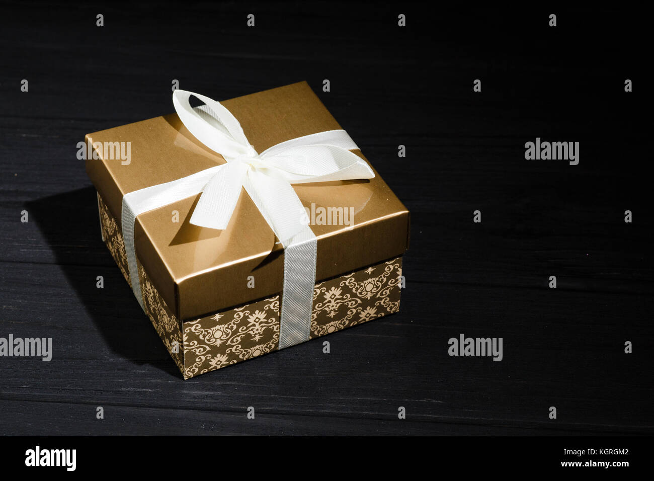 golden luxury box on black wood background Stock Photo - Alamy