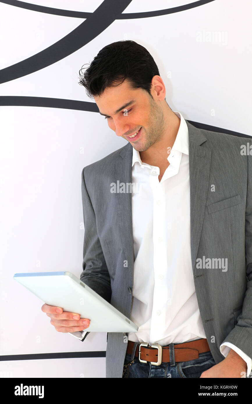 Young relaxed man using electronic tablet Stock Photo - Alamy