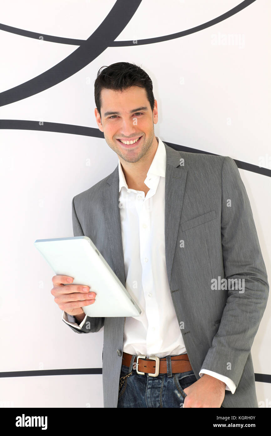 Young relaxed man using electronic tablet Stock Photo - Alamy
