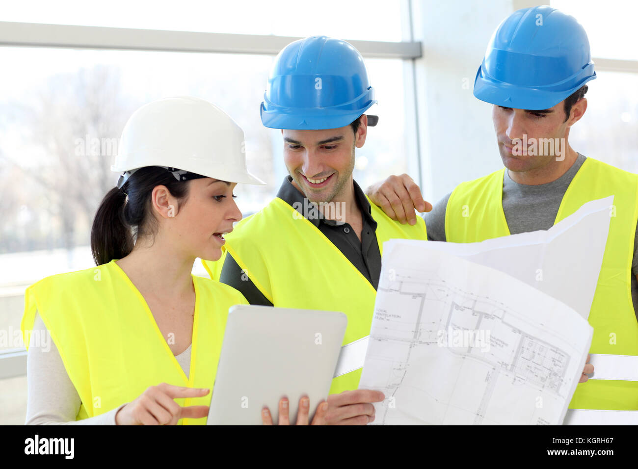 Construction workers looking at building plan Stock Photo - Alamy