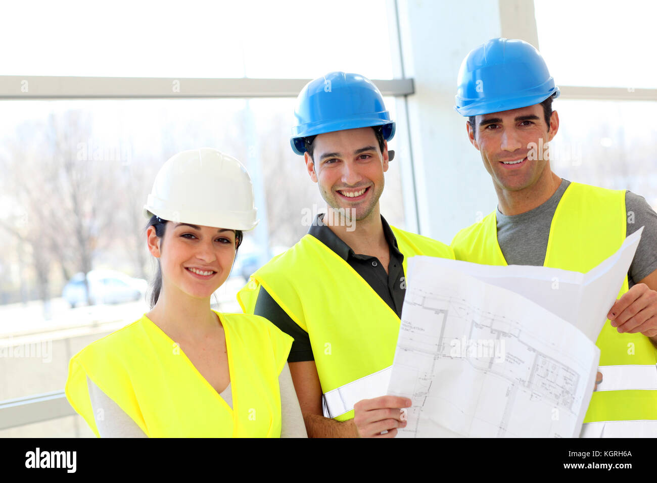 Construction workers looking at building plan Stock Photo - Alamy