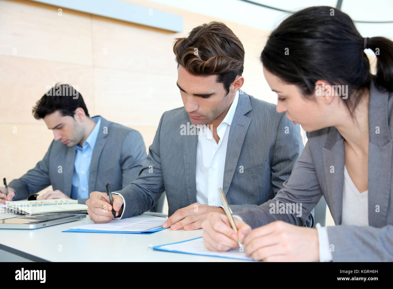 Young people signing application form Stock Photo - Alamy